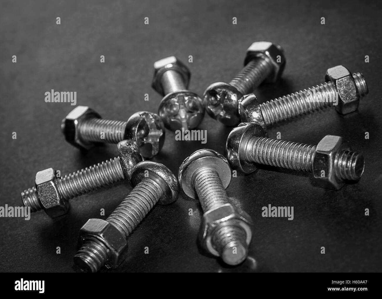 Several screws on black surface Stock Photo - Alamy