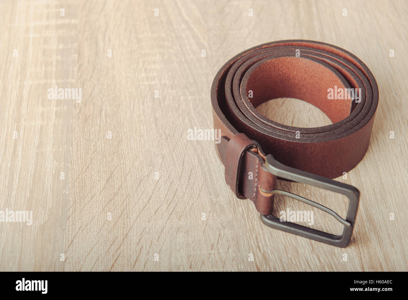 Leather belt on the wooden desk table Stock Photo - Alamy