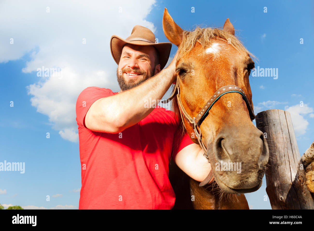Portrait of smiling cowboy with his brown horse Stock Photo - Alamy