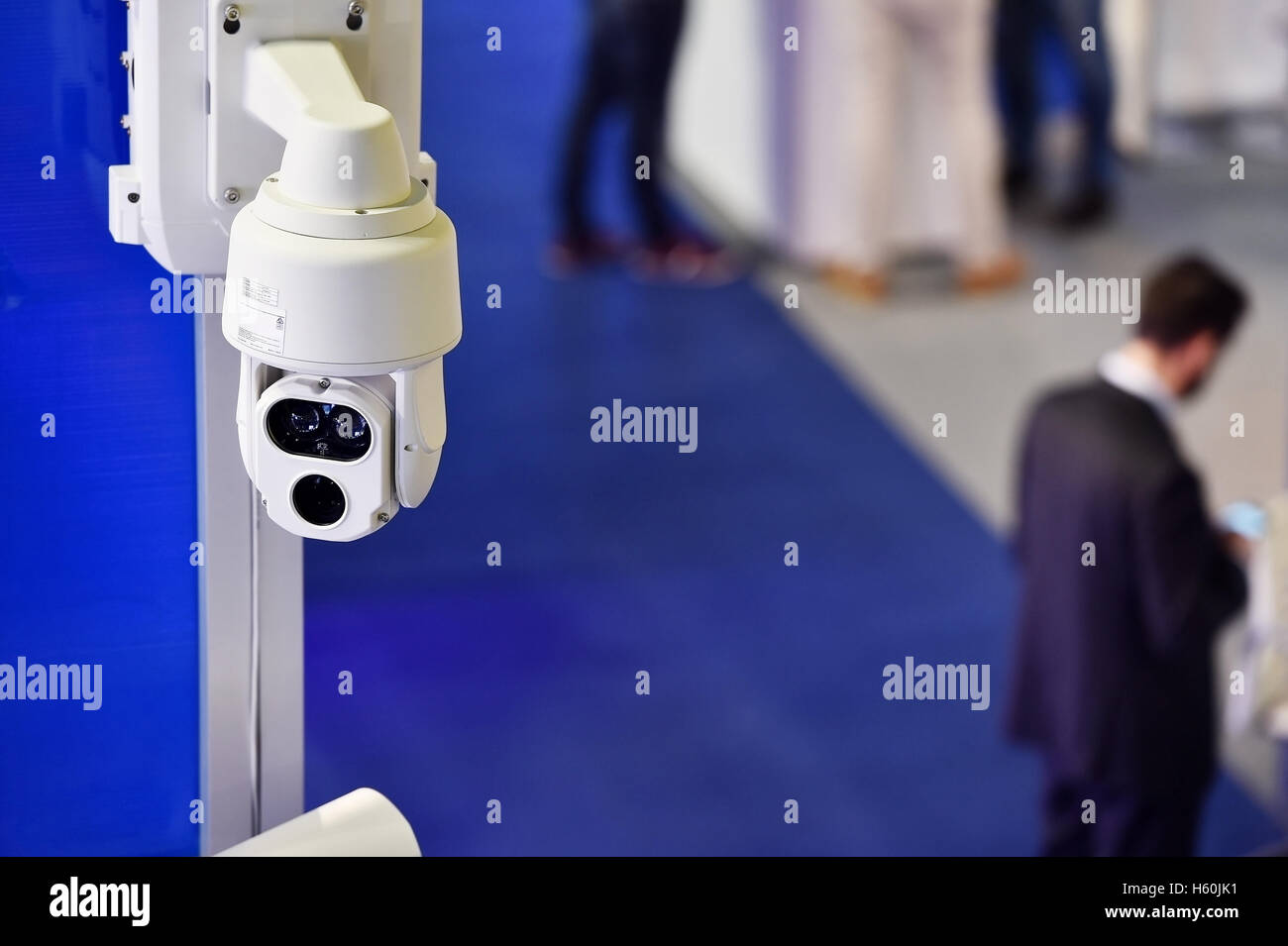 Surveillance camera inside a company with people in the background ...