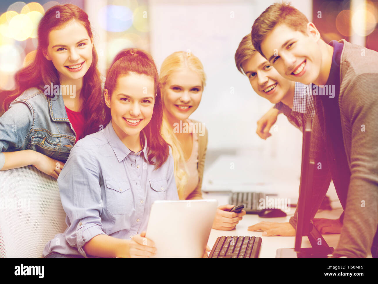 students with computer monitor and tablet pc Stock Photo - Alamy