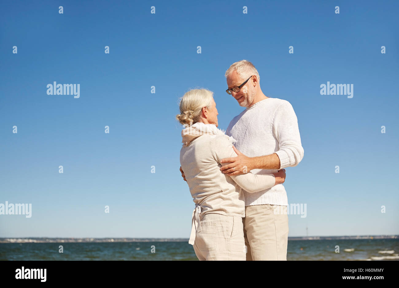 Mature couple hugging on beach hi-res stock photography and images - Alamy