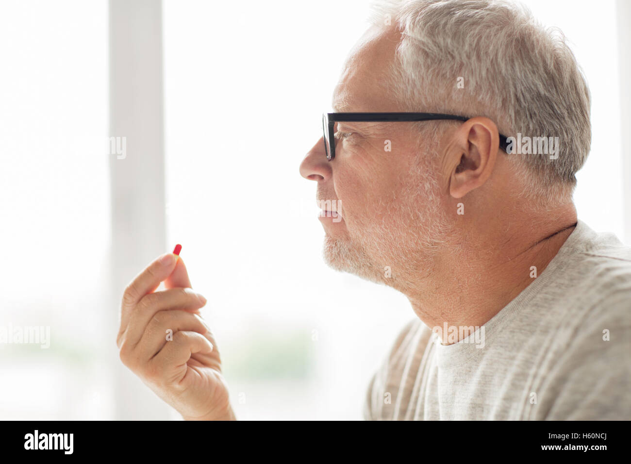 Elderly man taking pill hi-res stock photography and images - Alamy