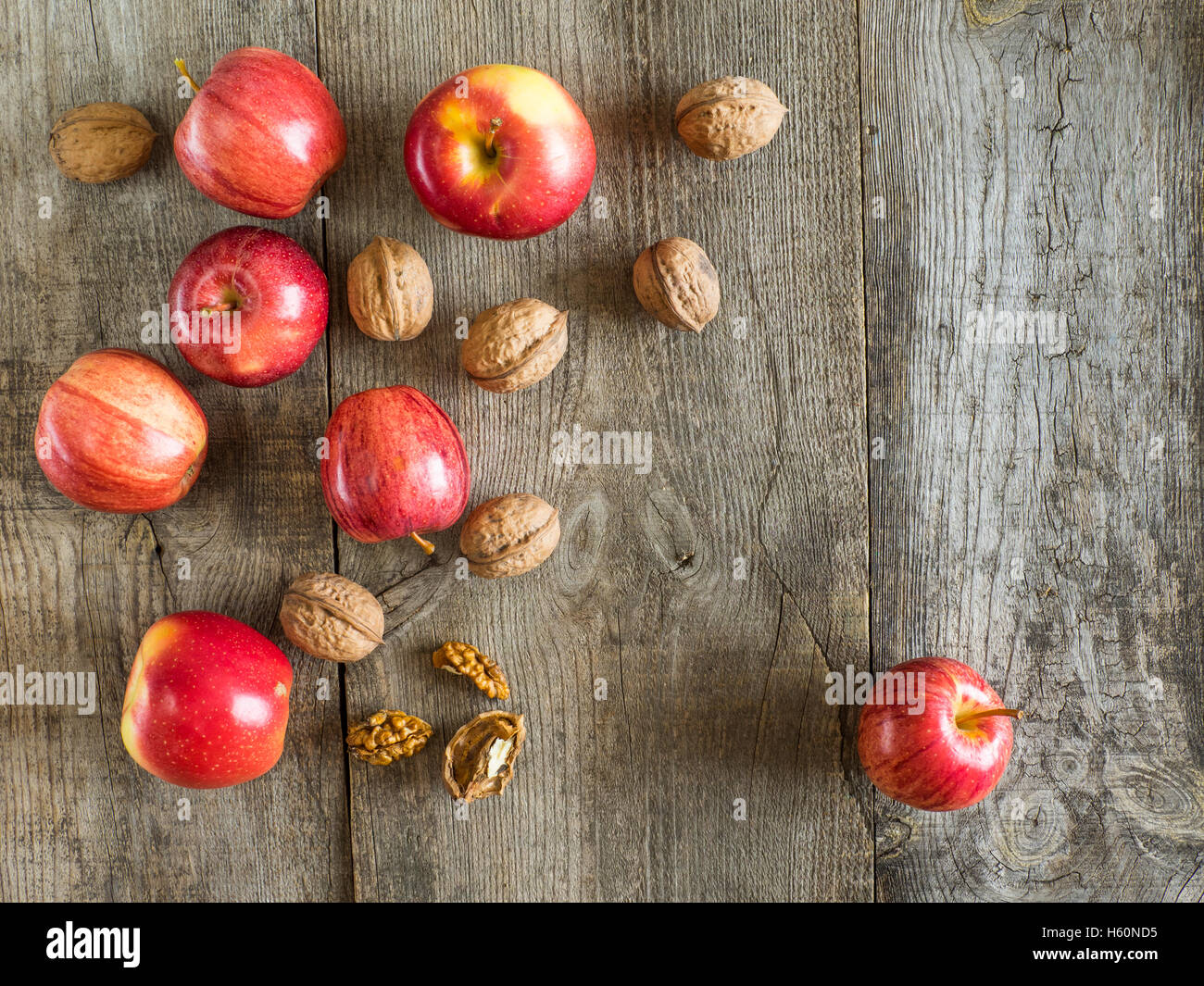 Overhead view of red apples and walnuts on rustic wooden boards Stock ...
