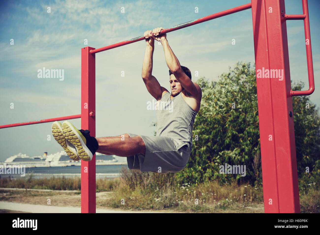 Young man flexing muscles exercising hi-res stock photography and ...