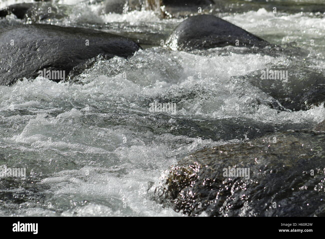 Rushing water flowing of over rocks in a canyon. Fast shutter speed ...