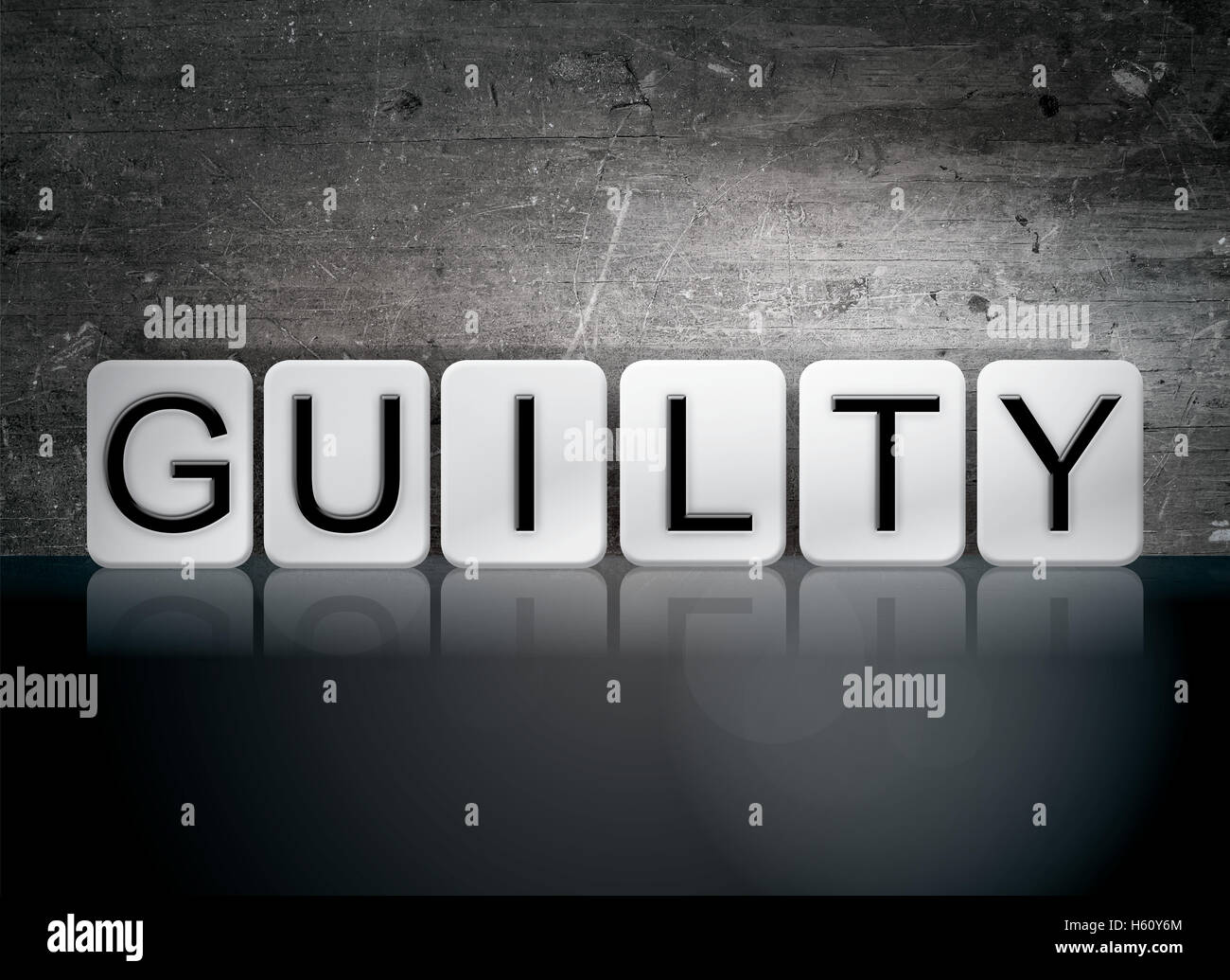The word "Guilty" written in white tiles against a dark vintage grunge ...