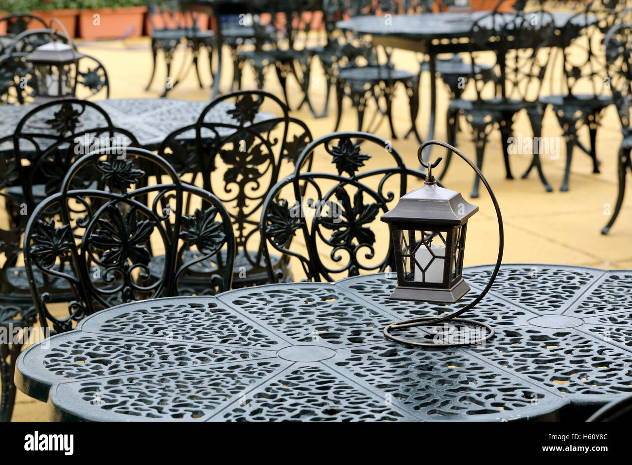 chairs and tables with old lantern, outdoor restaurant Stock Photo - Alamy