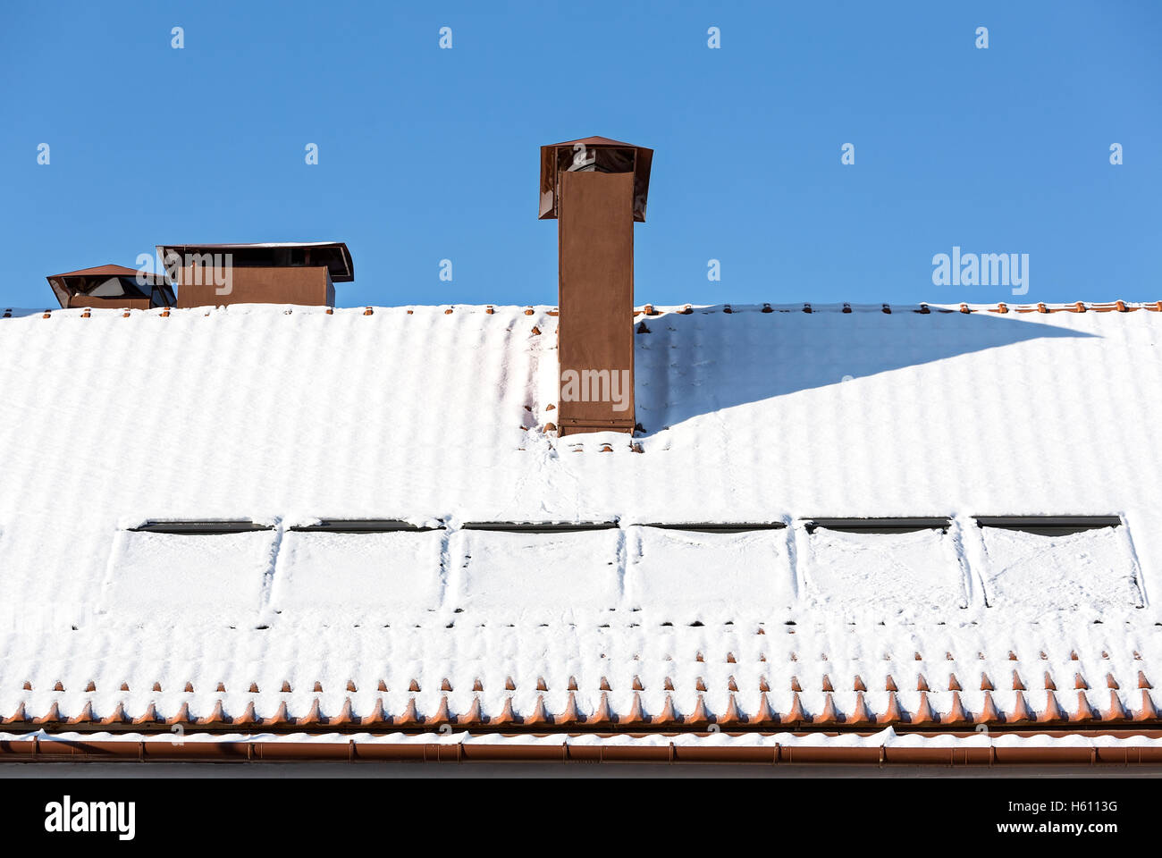 Chimney and dormer windows on roof covered by snow Stock Photo - Alamy