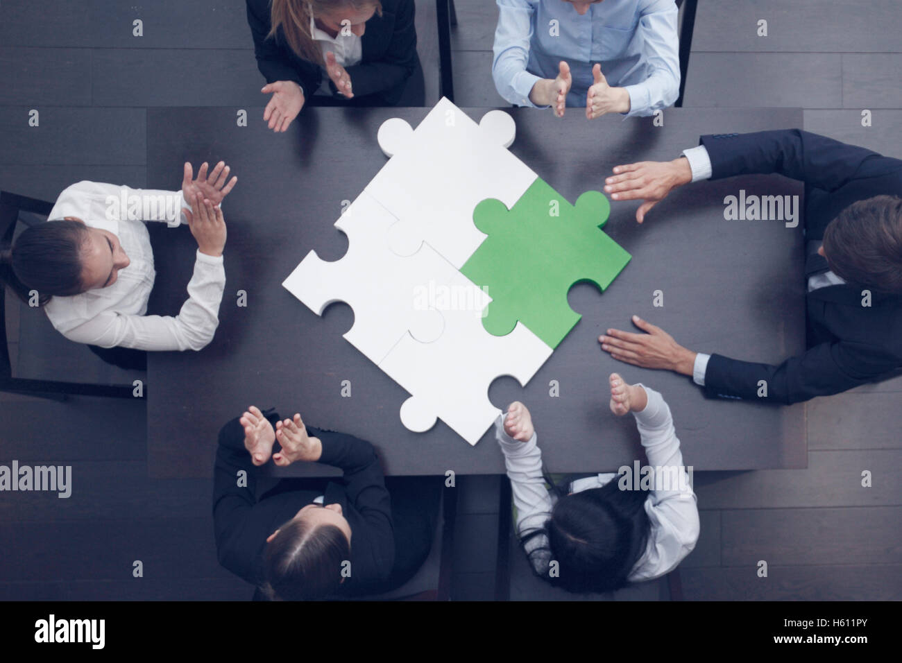 Group of business people assembling jigsaw puzzle, team support and ...