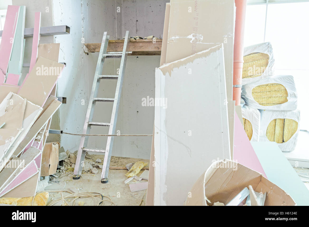 Crushed segments of gypsum drywall are dropped in pile at building site ...