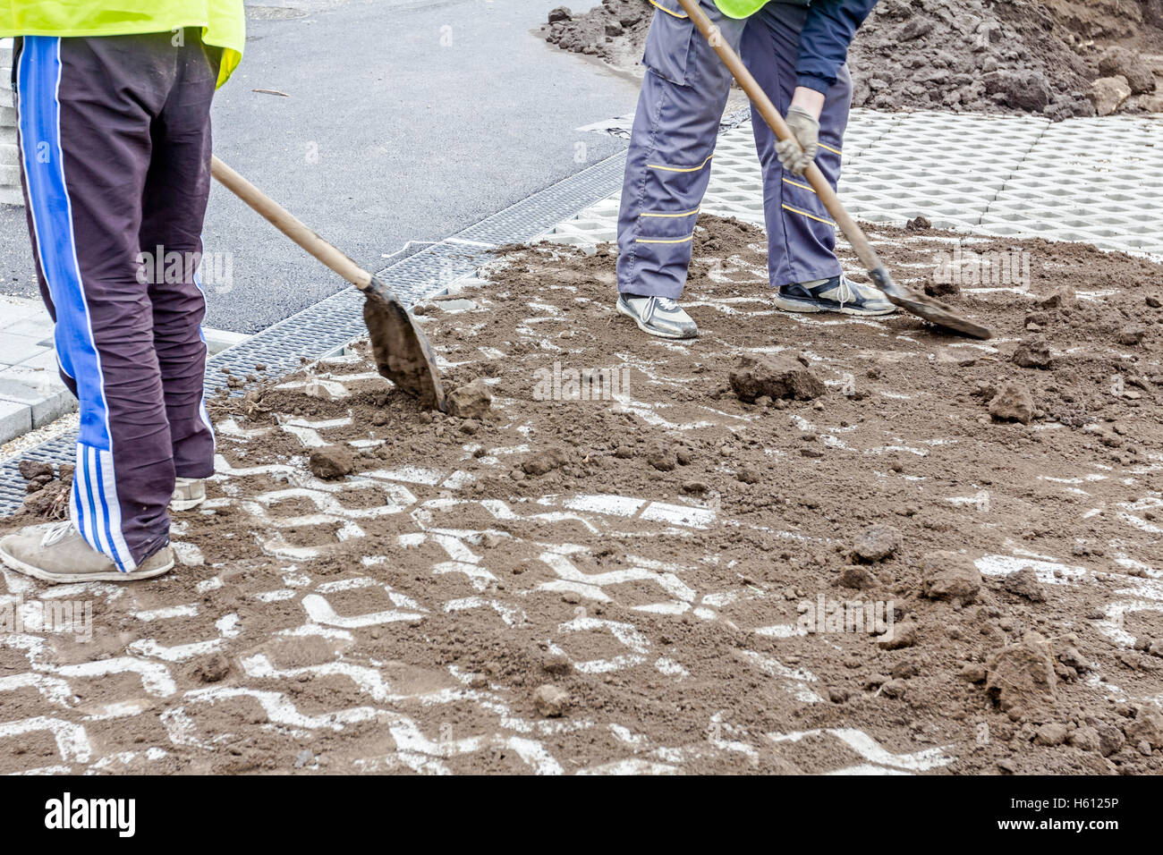 Workers are filling out symmetrical and decorative precast cobblestone ...