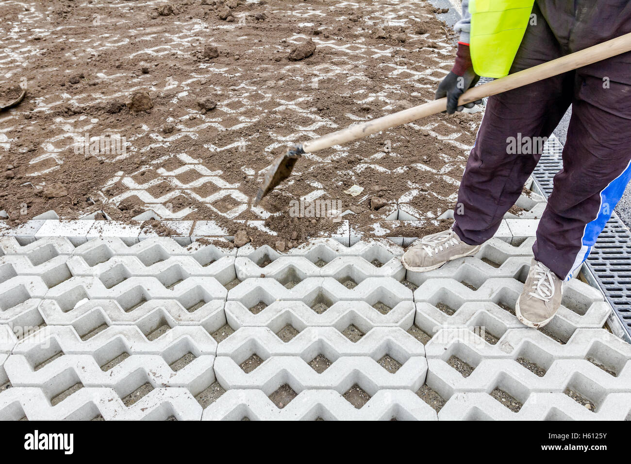 Workers are filling out symmetrical and decorative precast cobblestone ...