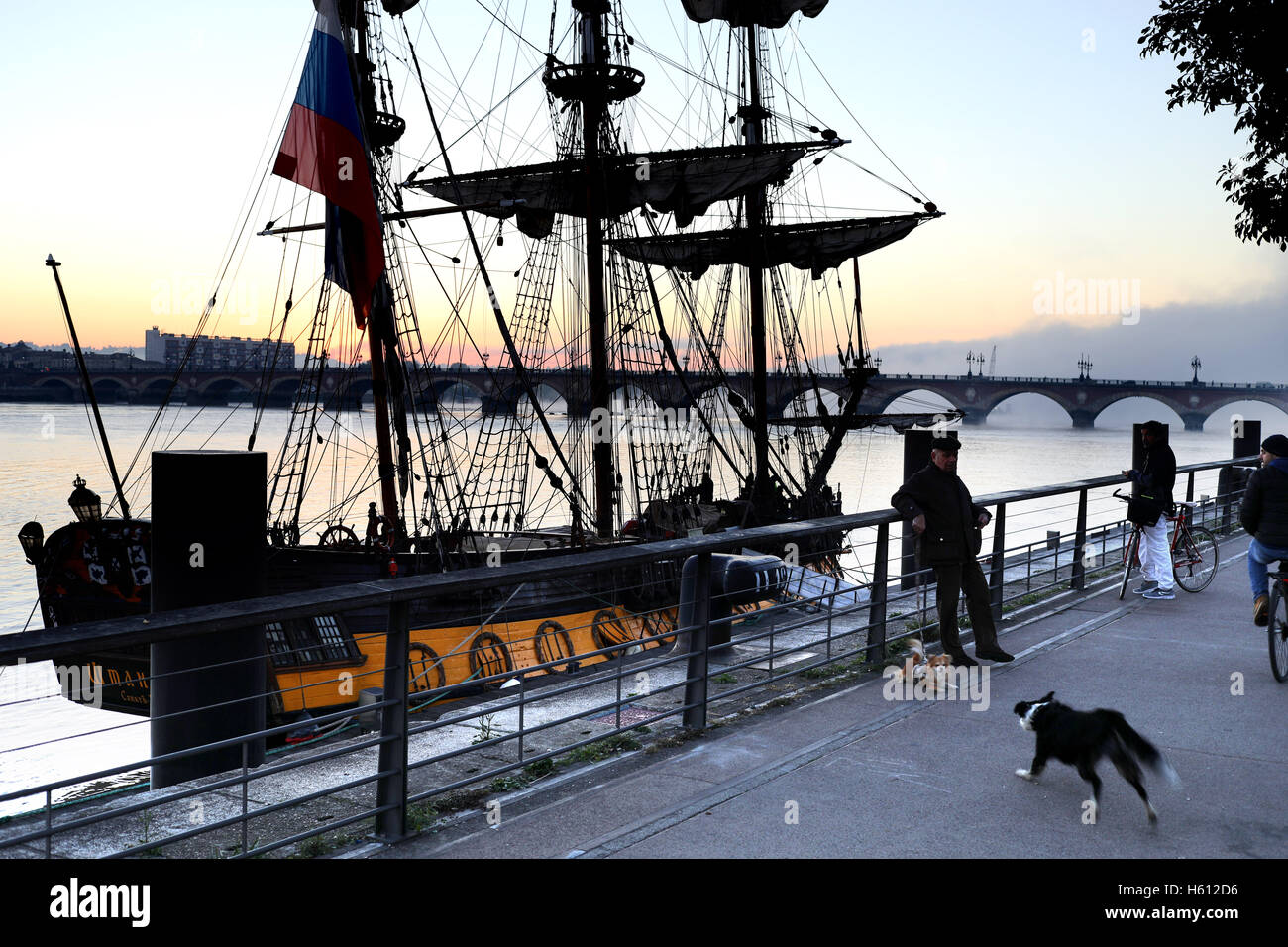 Old Russian clipper moored on Garonne river in front of stone bridge ...