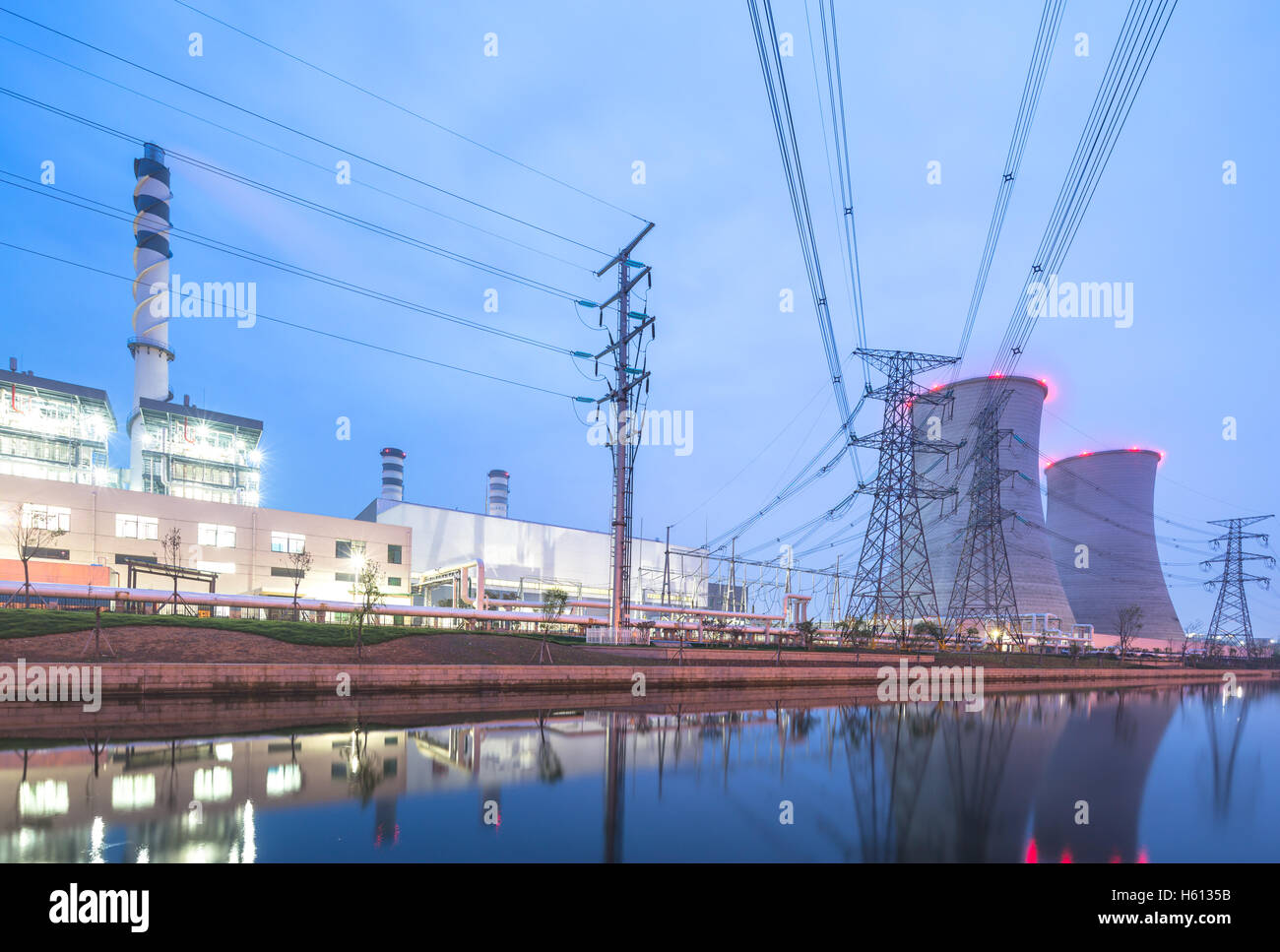 modern power station near river at twilight Stock Photo - Alamy