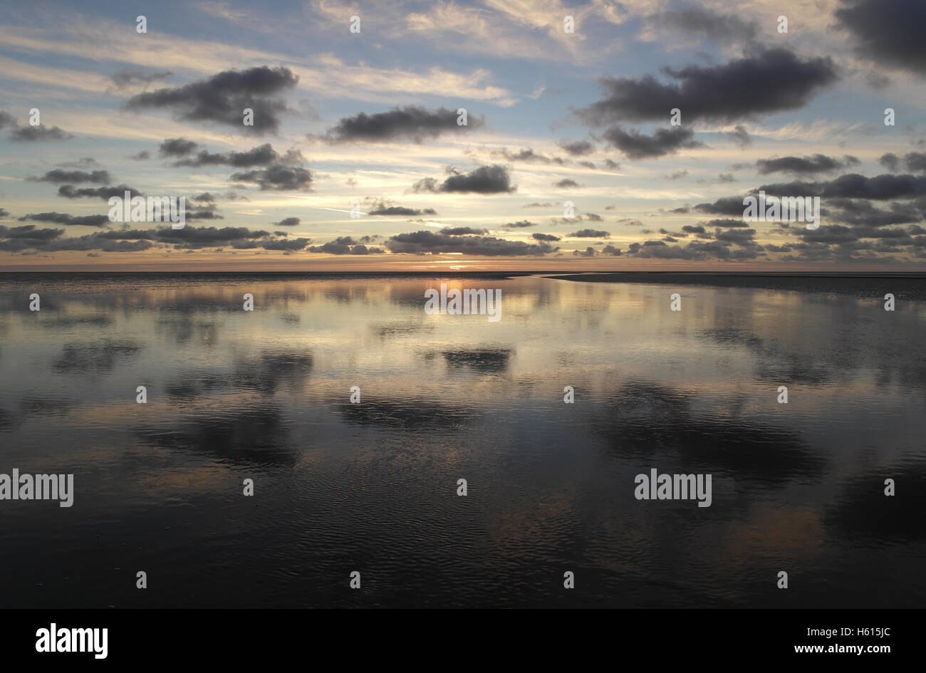 Grey stratocumulus clouds reflecting in a sea water channel on an ...