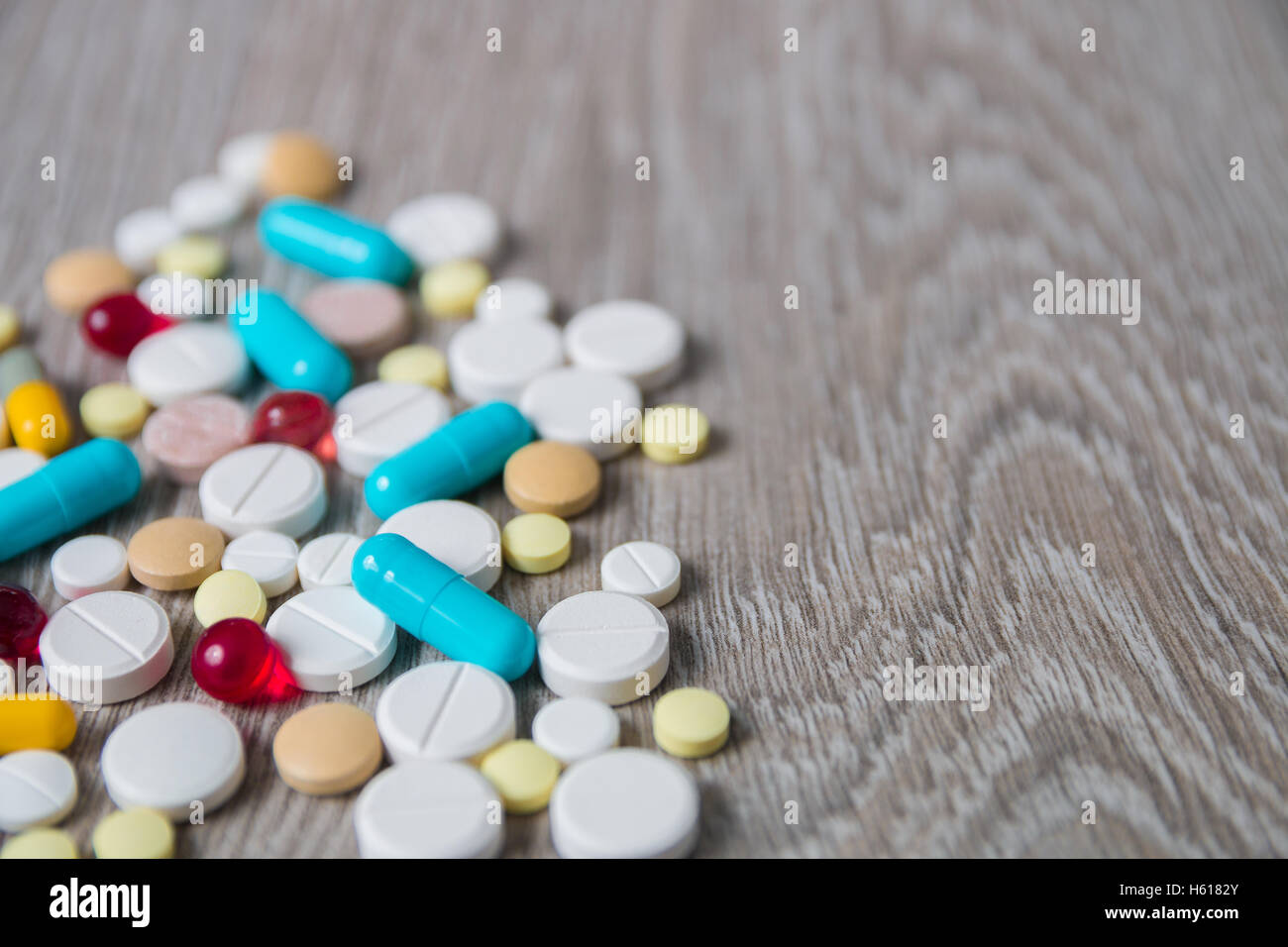 A lot of colorful medication and pills from above on grey wooden ...