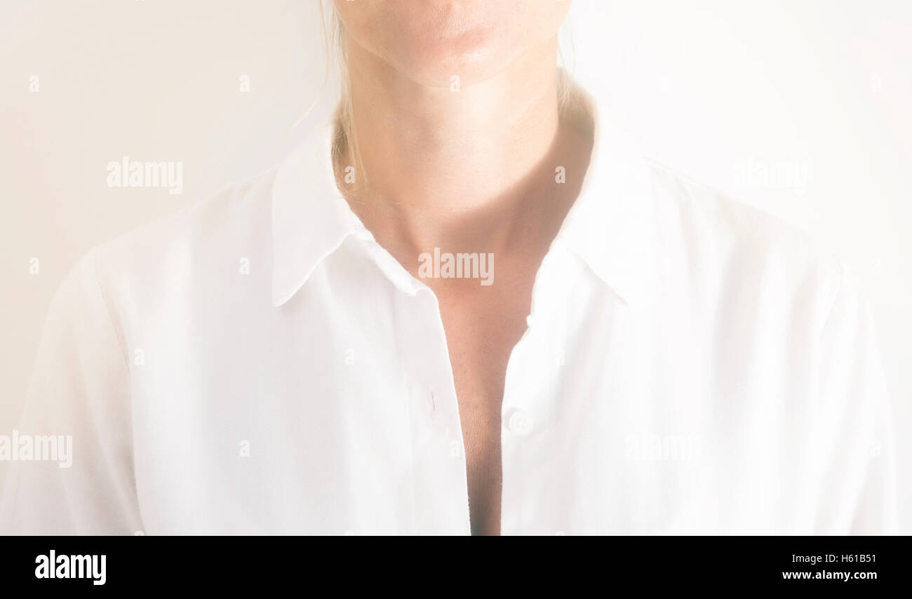 closeup of the neck of woman wearing a white shirt in bright soft light ...