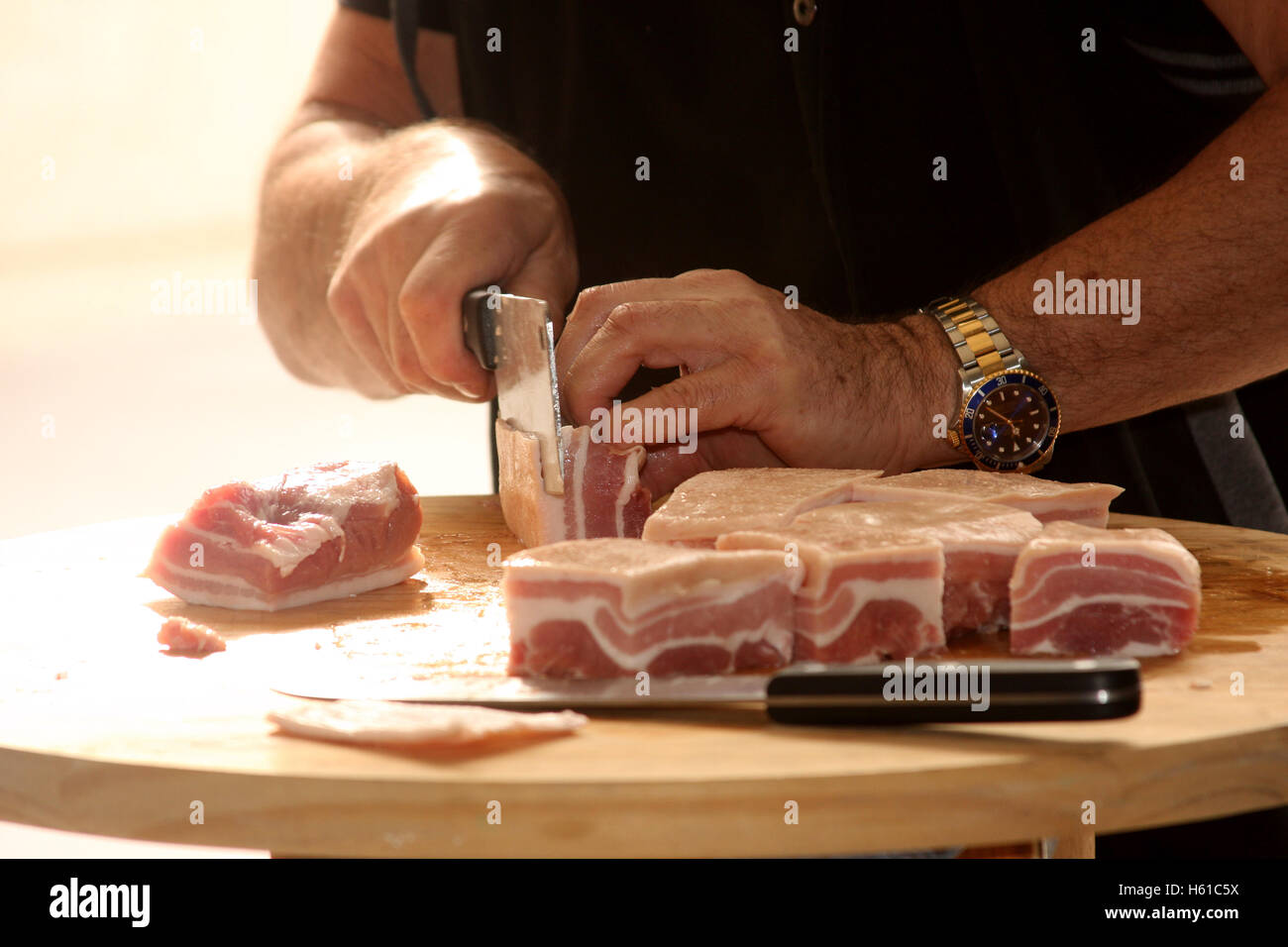 Slicing raw pork meat on cutting board Stock Photo - Alamy