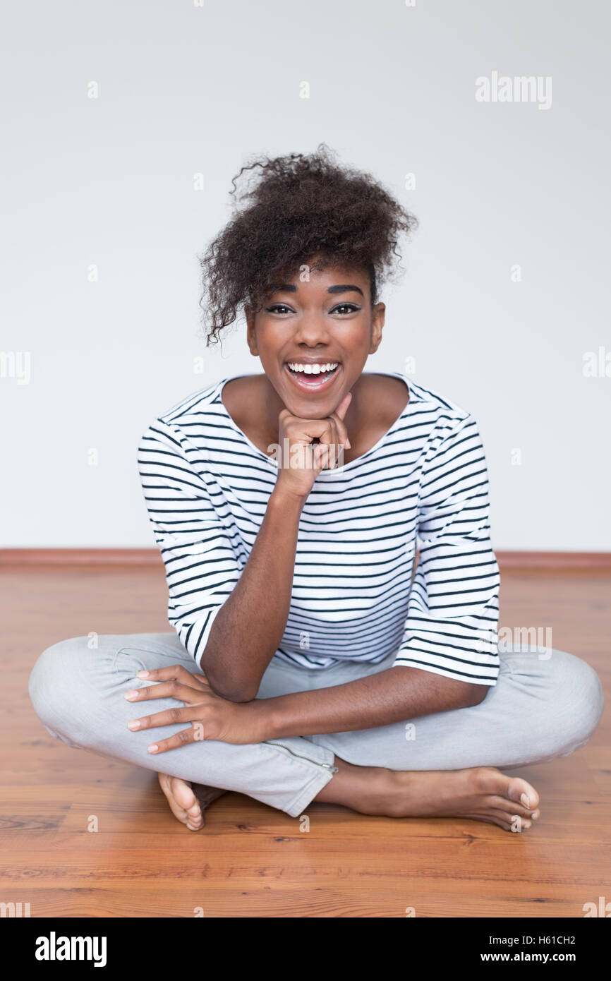 Portrait of a woman sitting on floor at home Stock Photo - Alamy