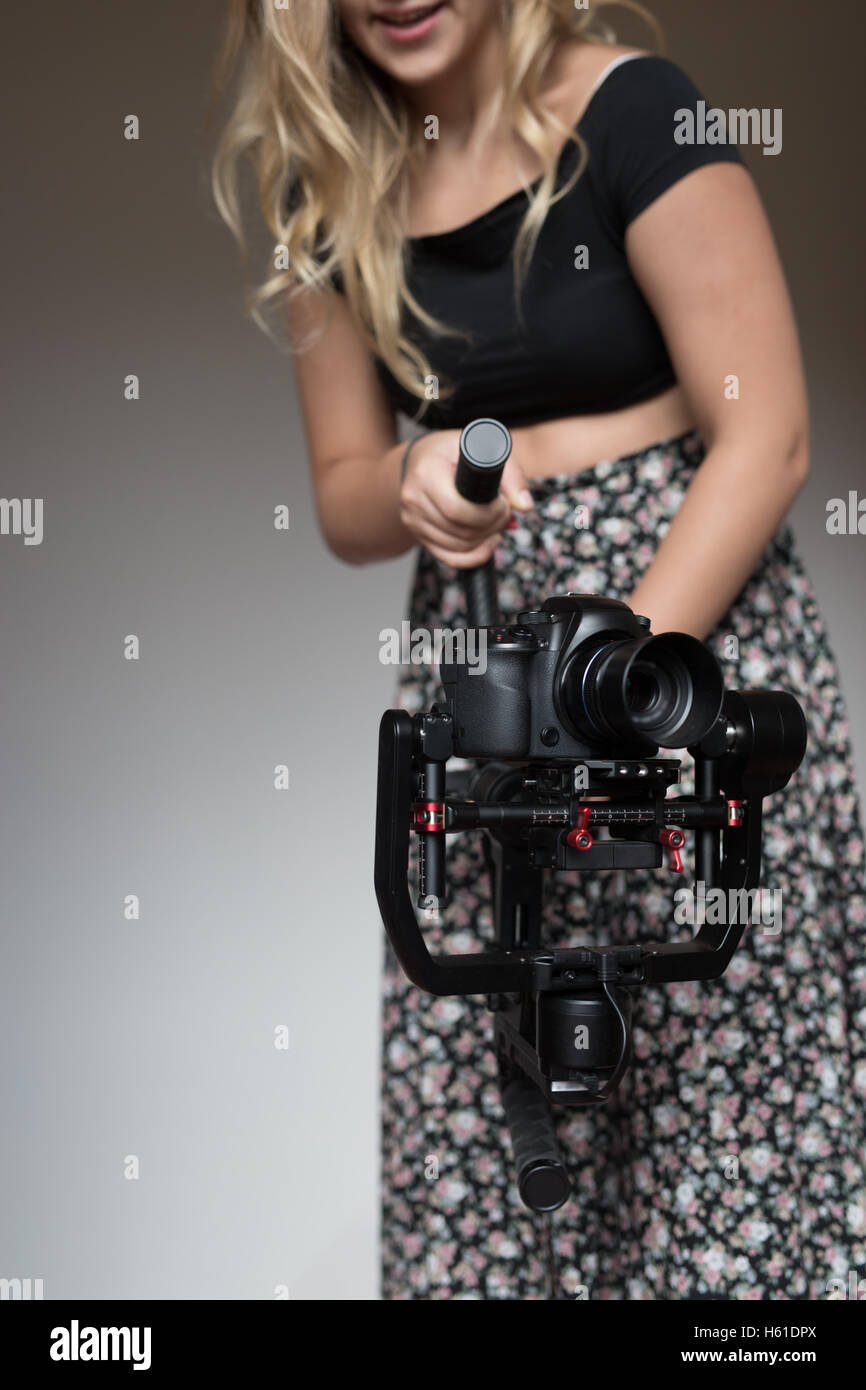 woman videographer using steady cam, Professional equipment helps to ...