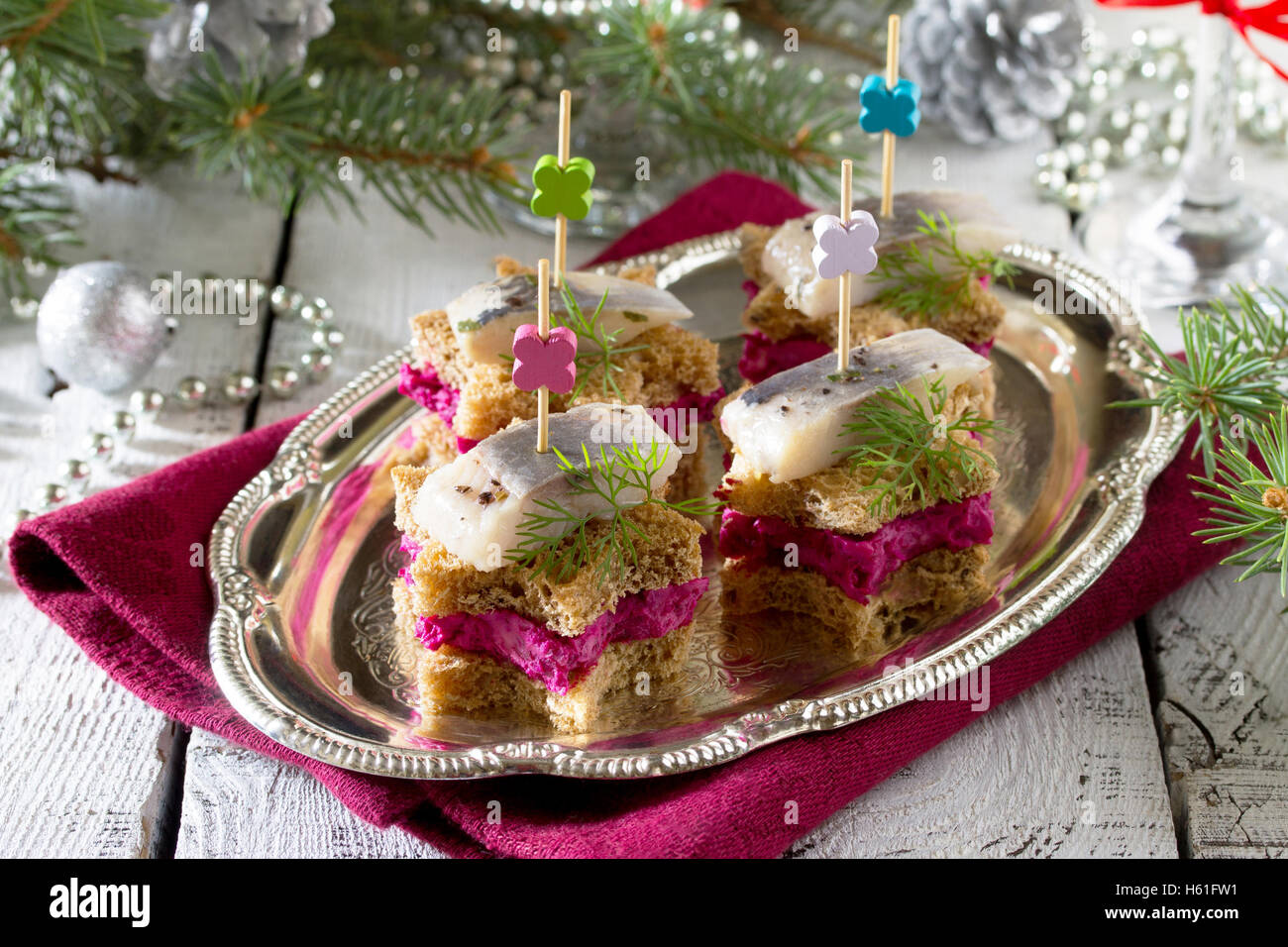 Canapes in the form of a star with pickled herring, beetroot and dill ...