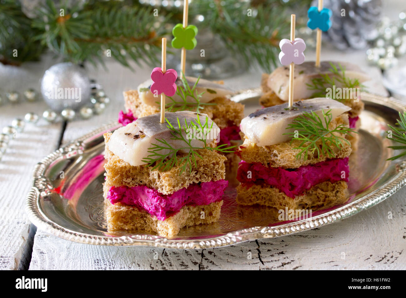 Canapes in the form of a star with pickled herring, beetroot and dill ...