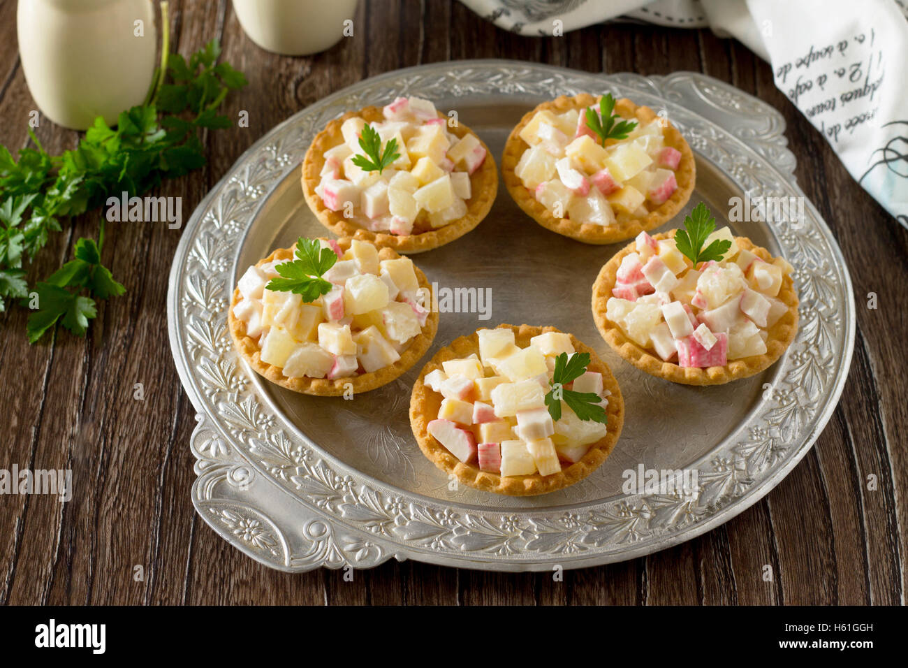 Holiday appetizer: tartlets with crab sticks, cheese and pineapple on a ...