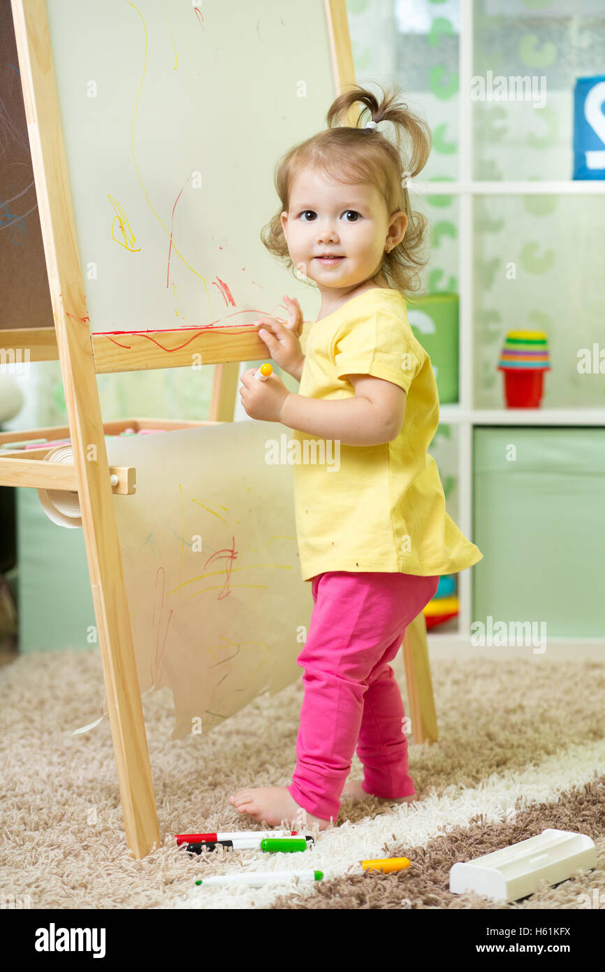 Child girl writing on whiteboard in nursery Stock Photo - Alamy