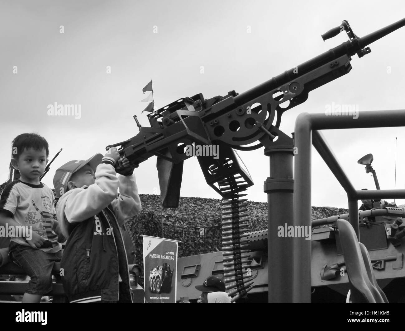 Kids acting as a gunner using a machine gun on an army vehicle in ...