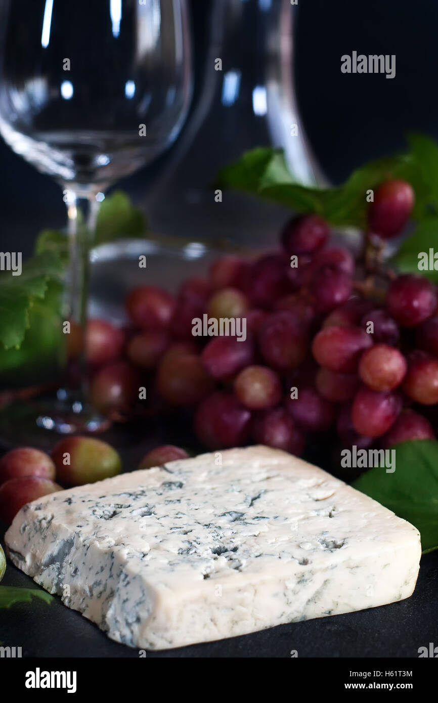 Blue cheese Dorblu with red grape on black background Stock Photo - Alamy