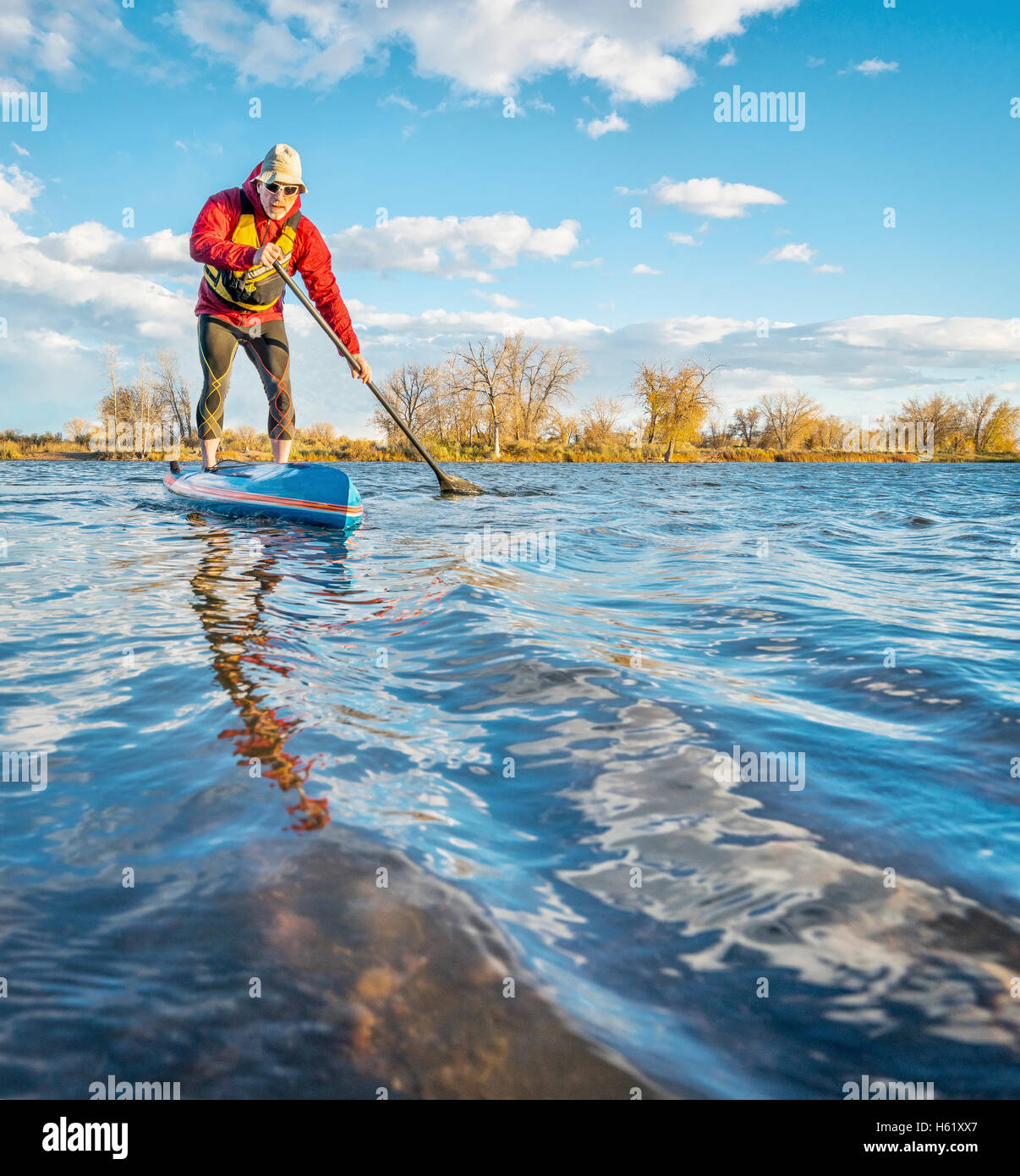 paddling stand up paddleboard on lake in Colorado, fall scenery with ...