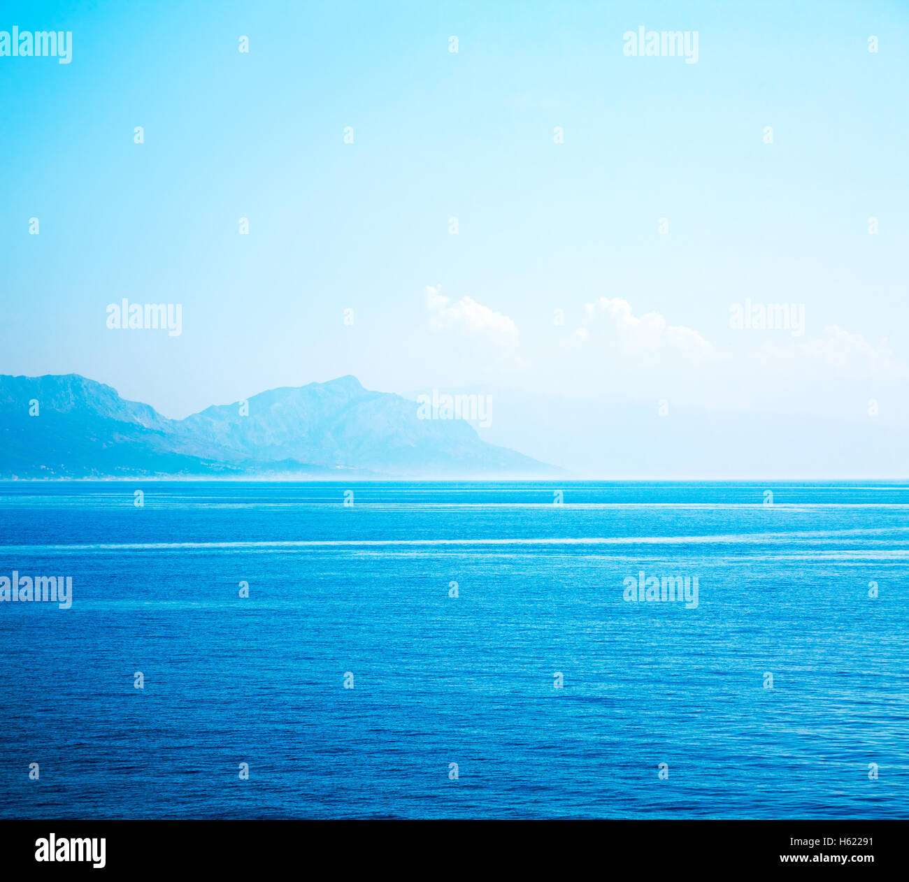 Calm Blue Sea with Mountains in Haze. Seascape Stock Photo - Alamy