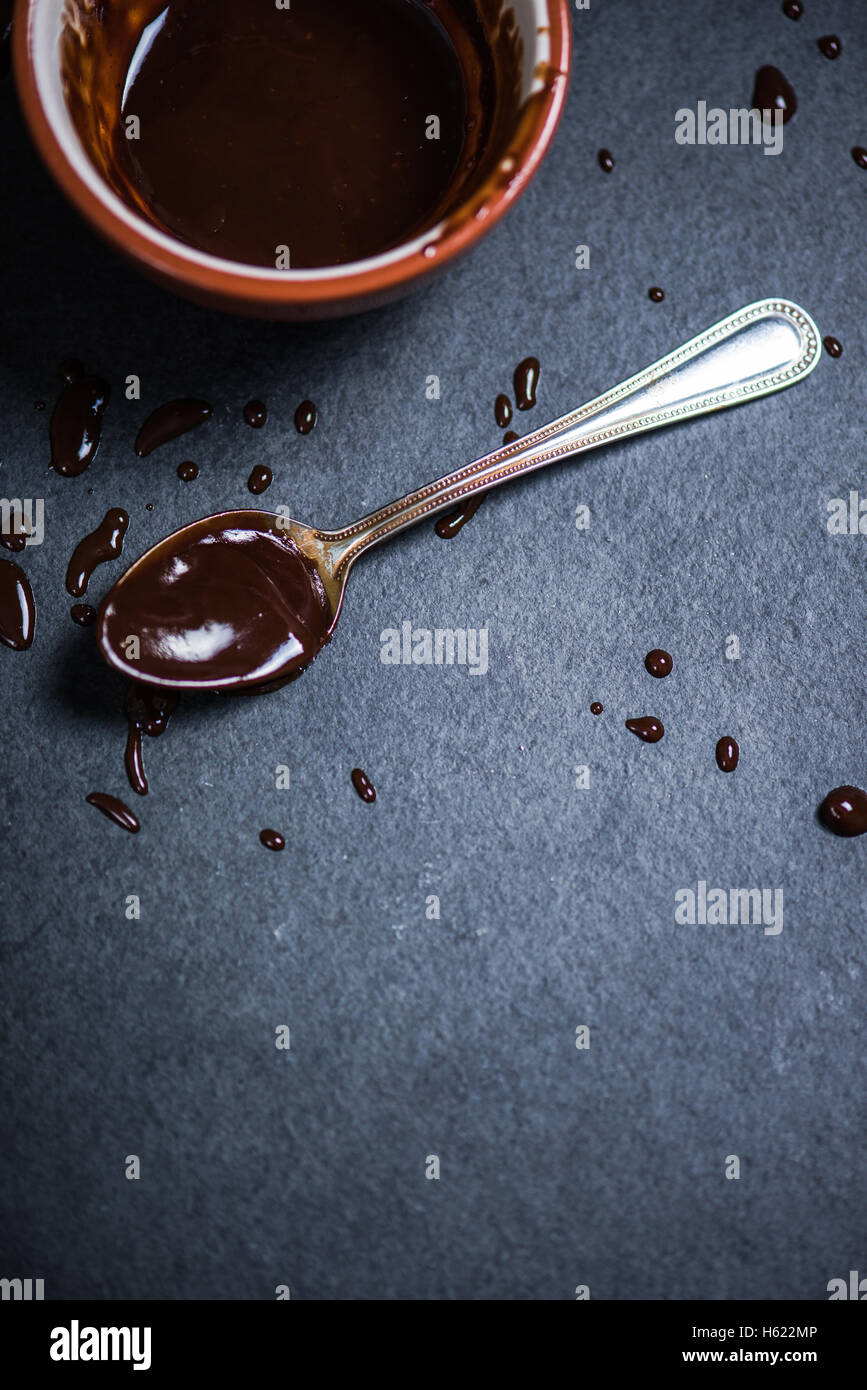 Melted hot dark chocolate, copy space border background on dark slate ...