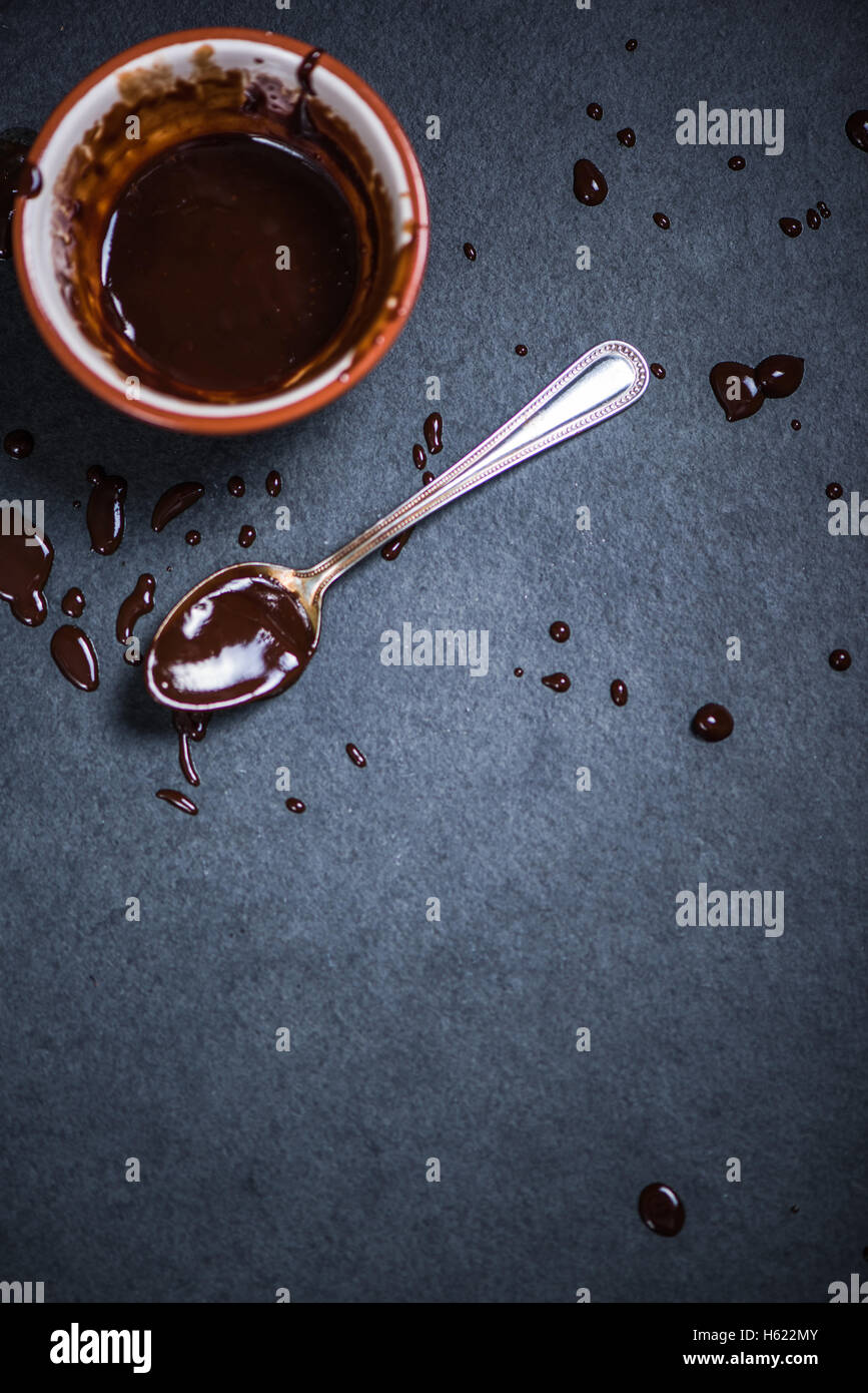 Melted hot dark chocolate, copy space border background on dark slate ...