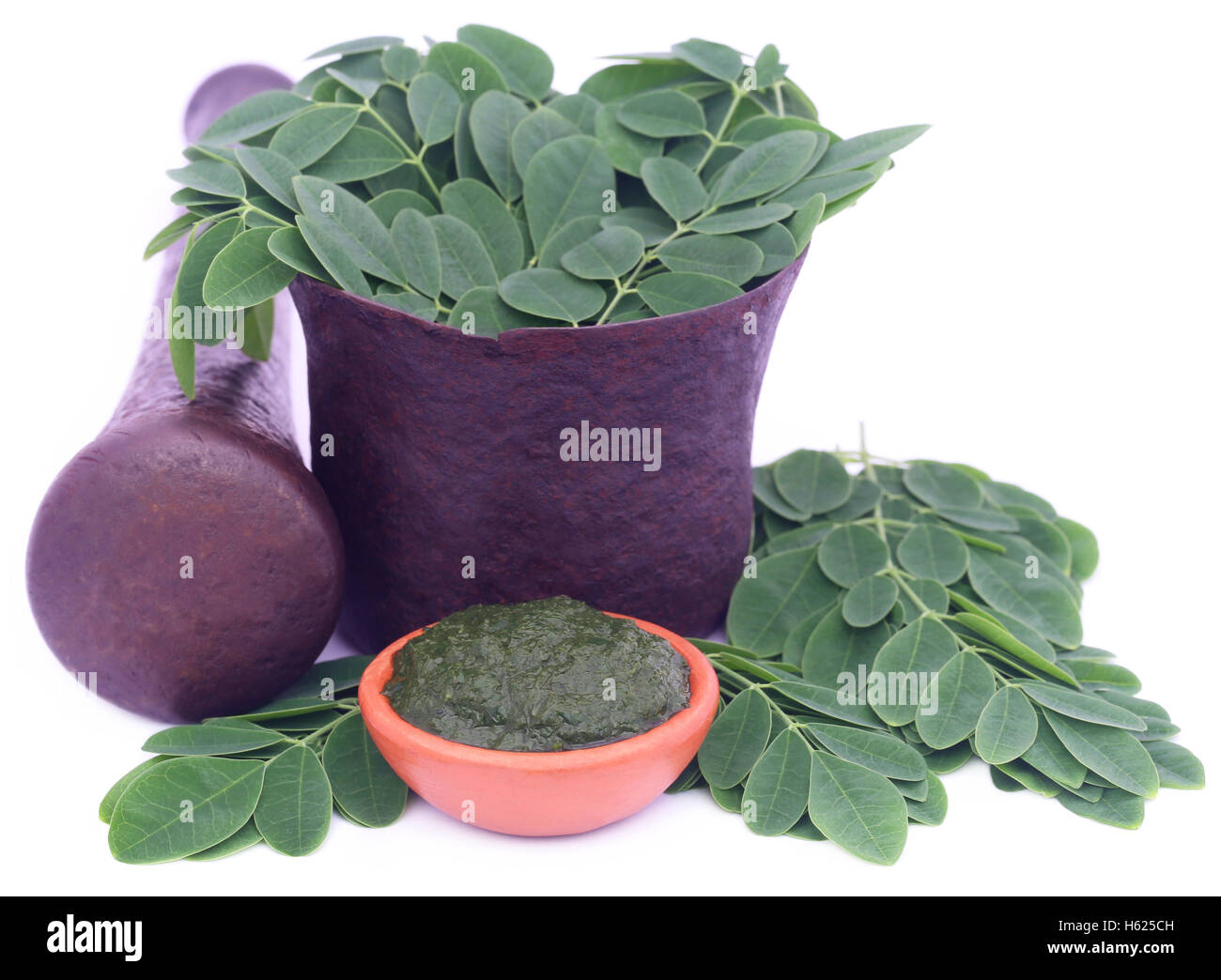 Edible moringa leaves in a vintage mortar with ground paste Stock Photo ...