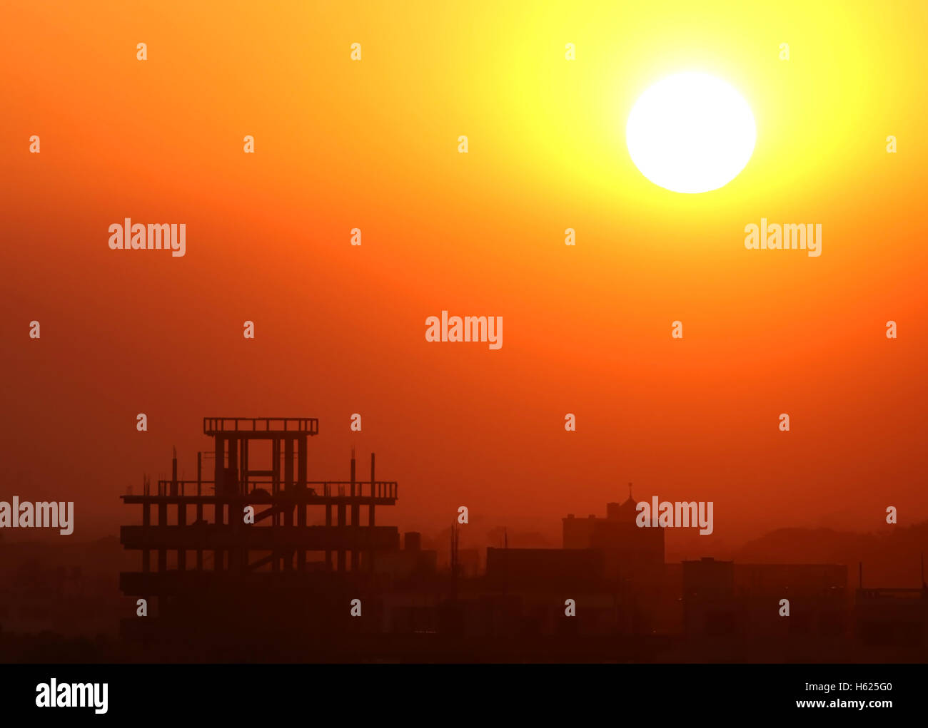 Setting sun behind construction building in Bangladesh Stock Photo - Alamy