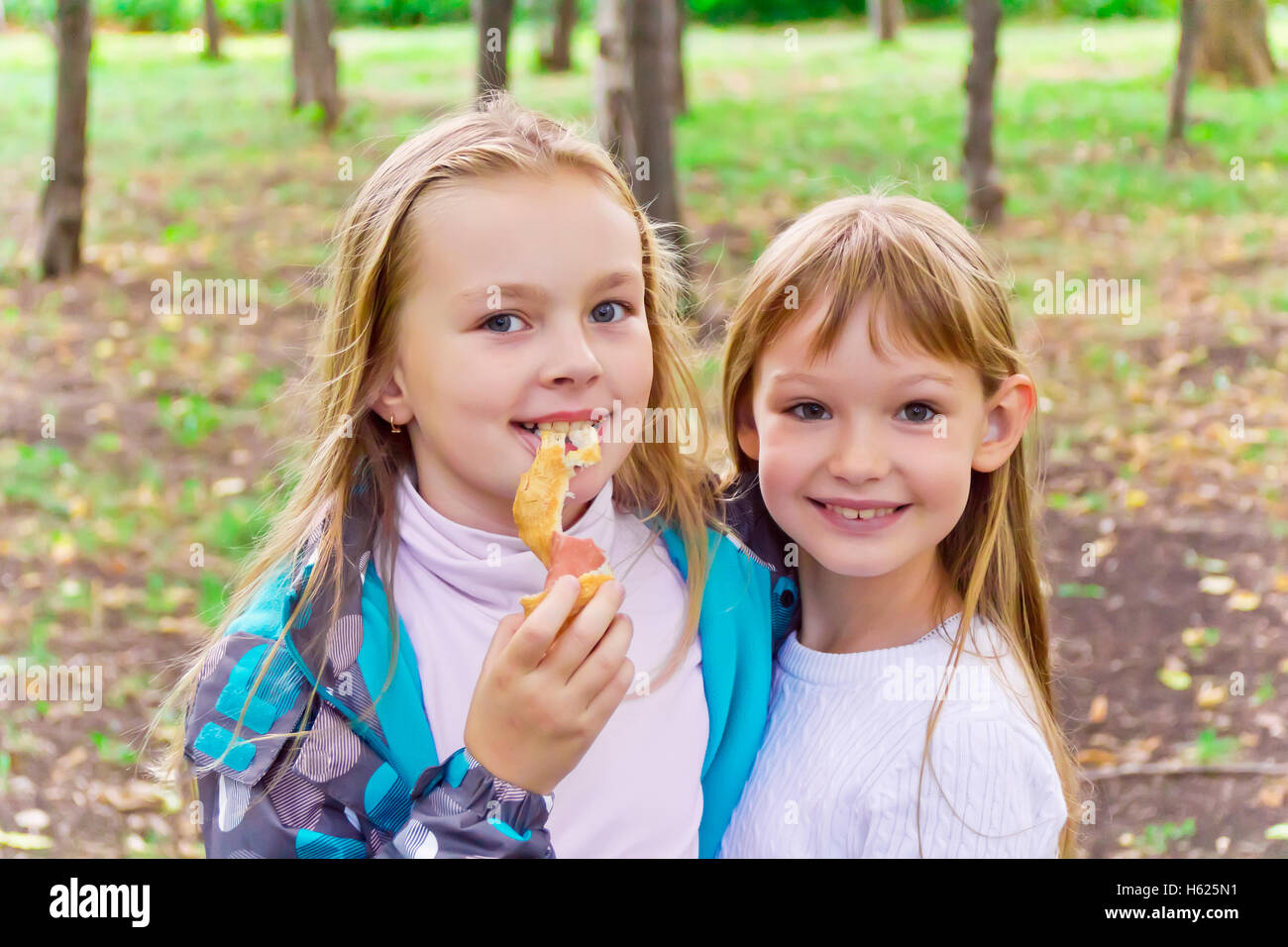 Photo of two eating girls in summer Stock Photo - Alamy