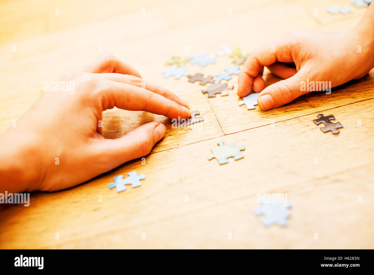 little kid playing with puzzles on wooden floor together with pa Stock ...
