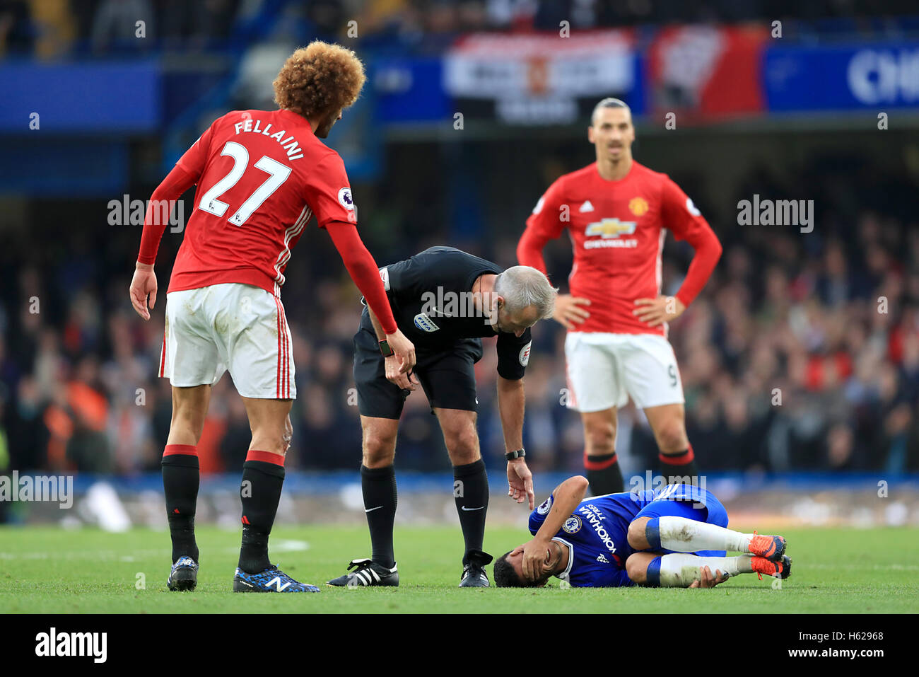Referee Martin Atkinson and Manchester United's Marouane Fellaini look ...