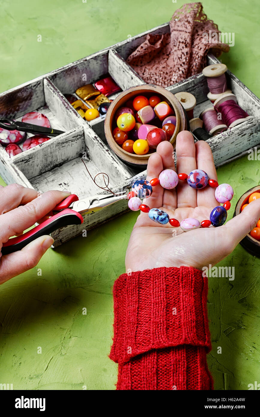drawer with beads and female hands collecting bracelet for the hand ...