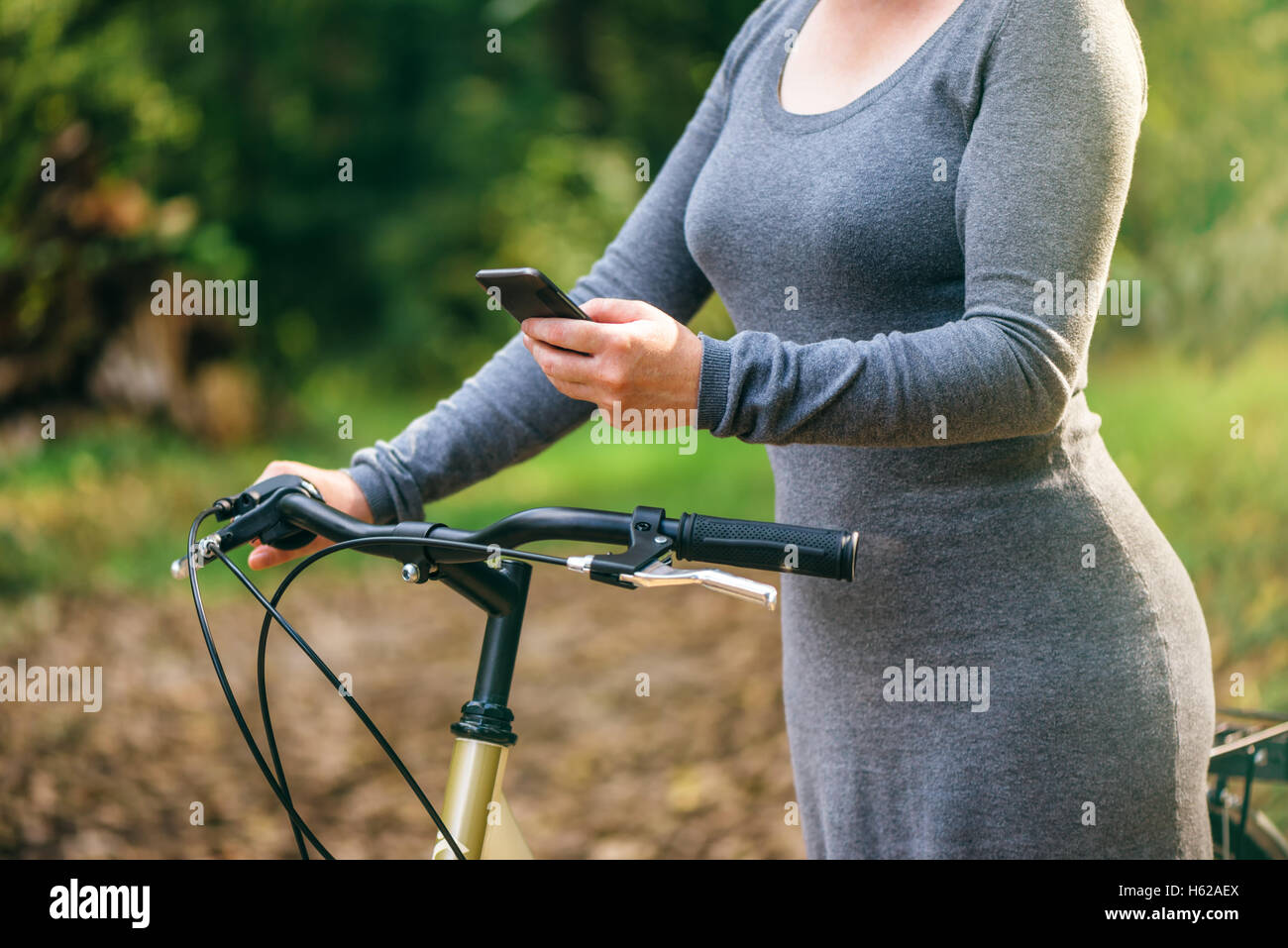 Female cyclist using mobile phone application during autumn season ...