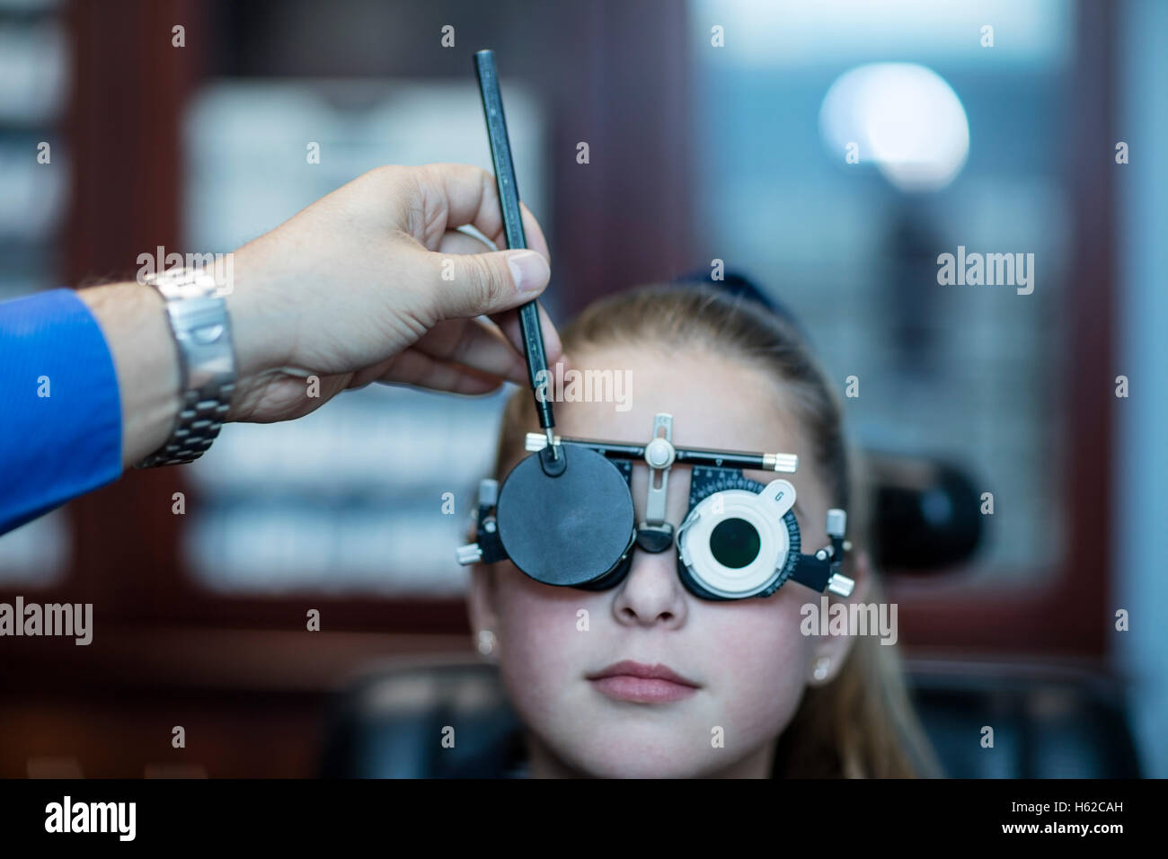 Girl doing eye test at optometrist Stock Photo - Alamy