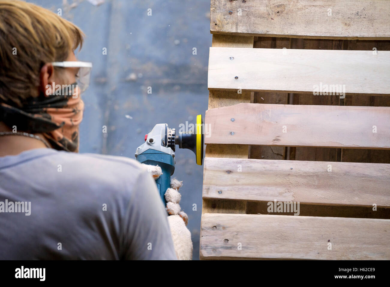 Man sanding pallet with a random orbital sander Stock Photo - Alamy