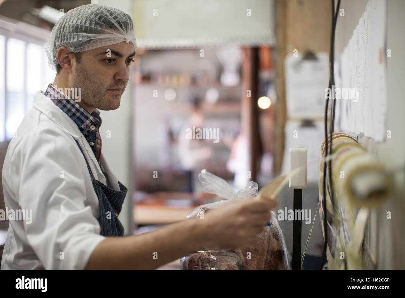 Butcher packing and labelling meat in butchery Stock Photo - Alamy