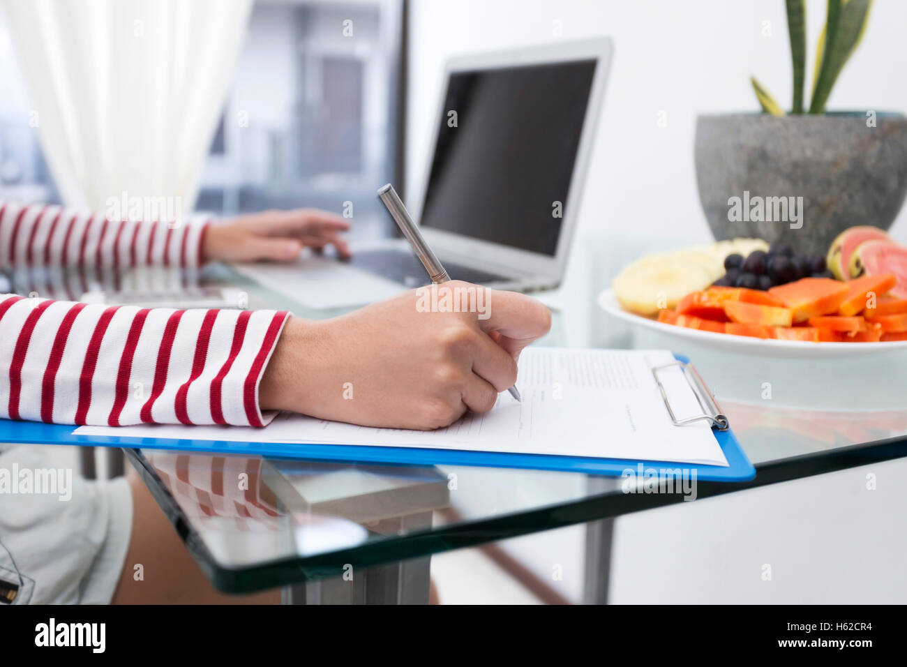 Woman taking notes on clipboard Stock Photo - Alamy