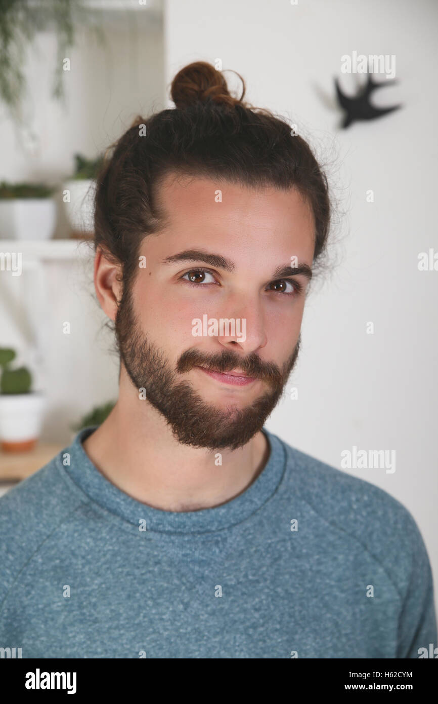 Portrait of young man with beard and bun Stock Photo - Alamy