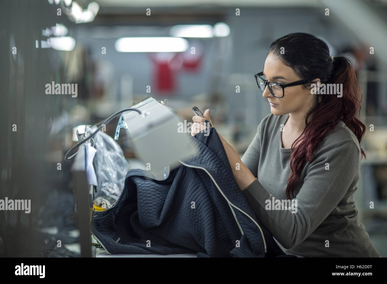 Seamstress in clothing factory sewing clothes Stock Photo - Alamy