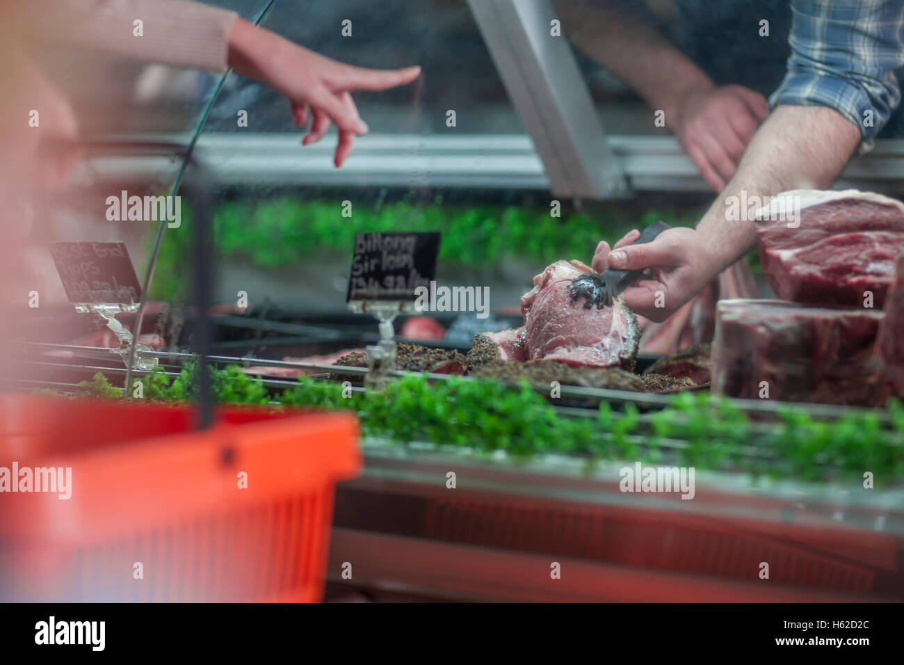 Client choosing meat from butchery display Stock Photo - Alamy