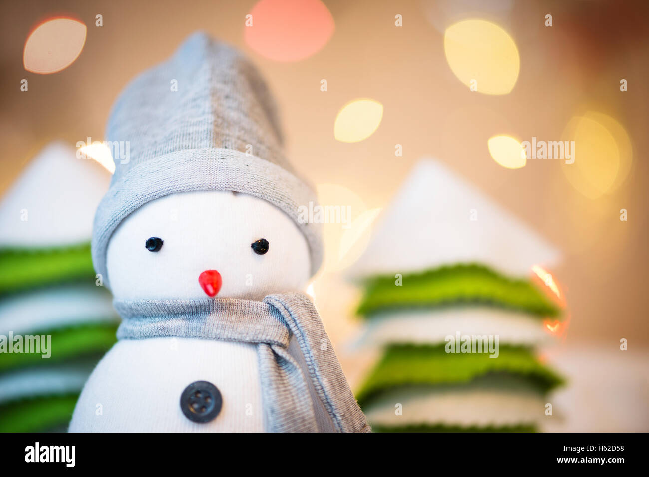 Detail of cute festive snowman with Christmas lights in background ...